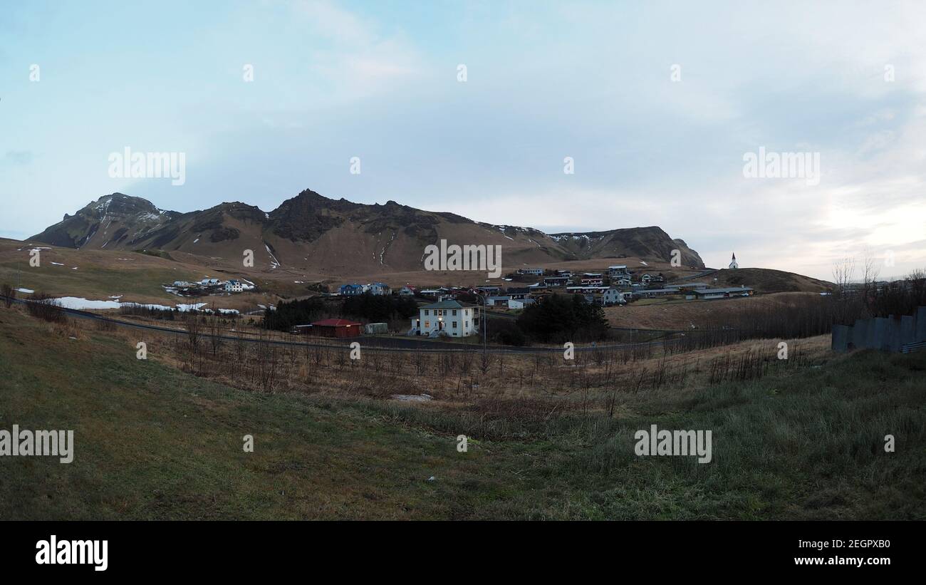 Vik town panoramic view, Iceland, houses sit under mountain range, and ...