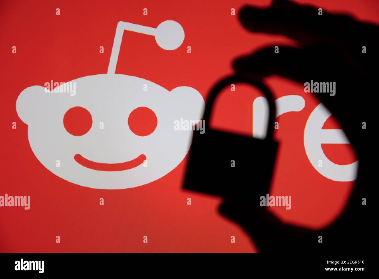 LONDON, UK - February 2021: Silhouette of padlock against Reddit logo ...