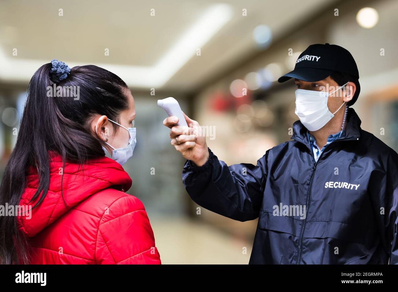 Security Guard Temperature Scan At Shopping Mall Stock Photo - Alamy