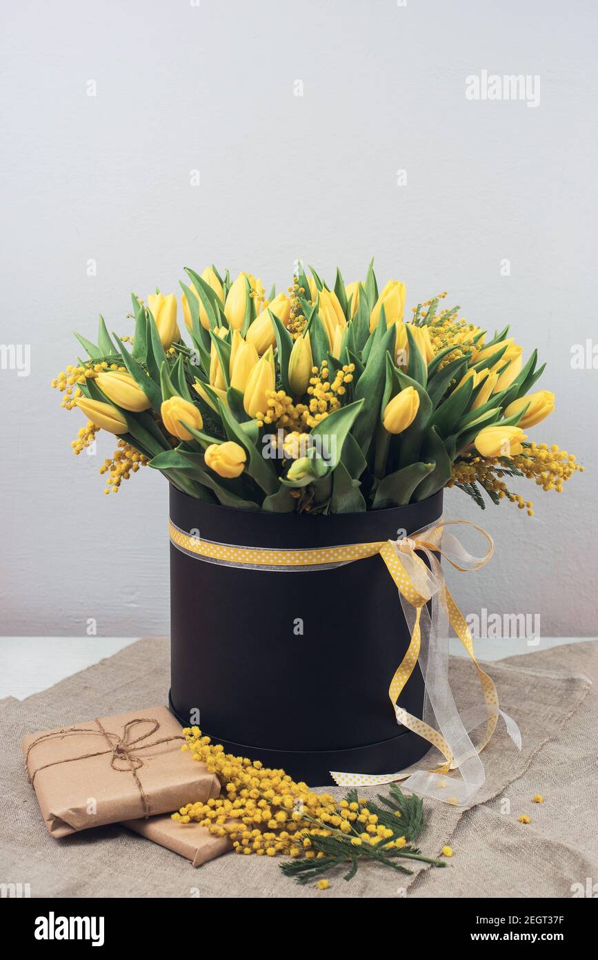 Bright spring bouquet of tulips and mimosa flowers. Mother's Day or ...