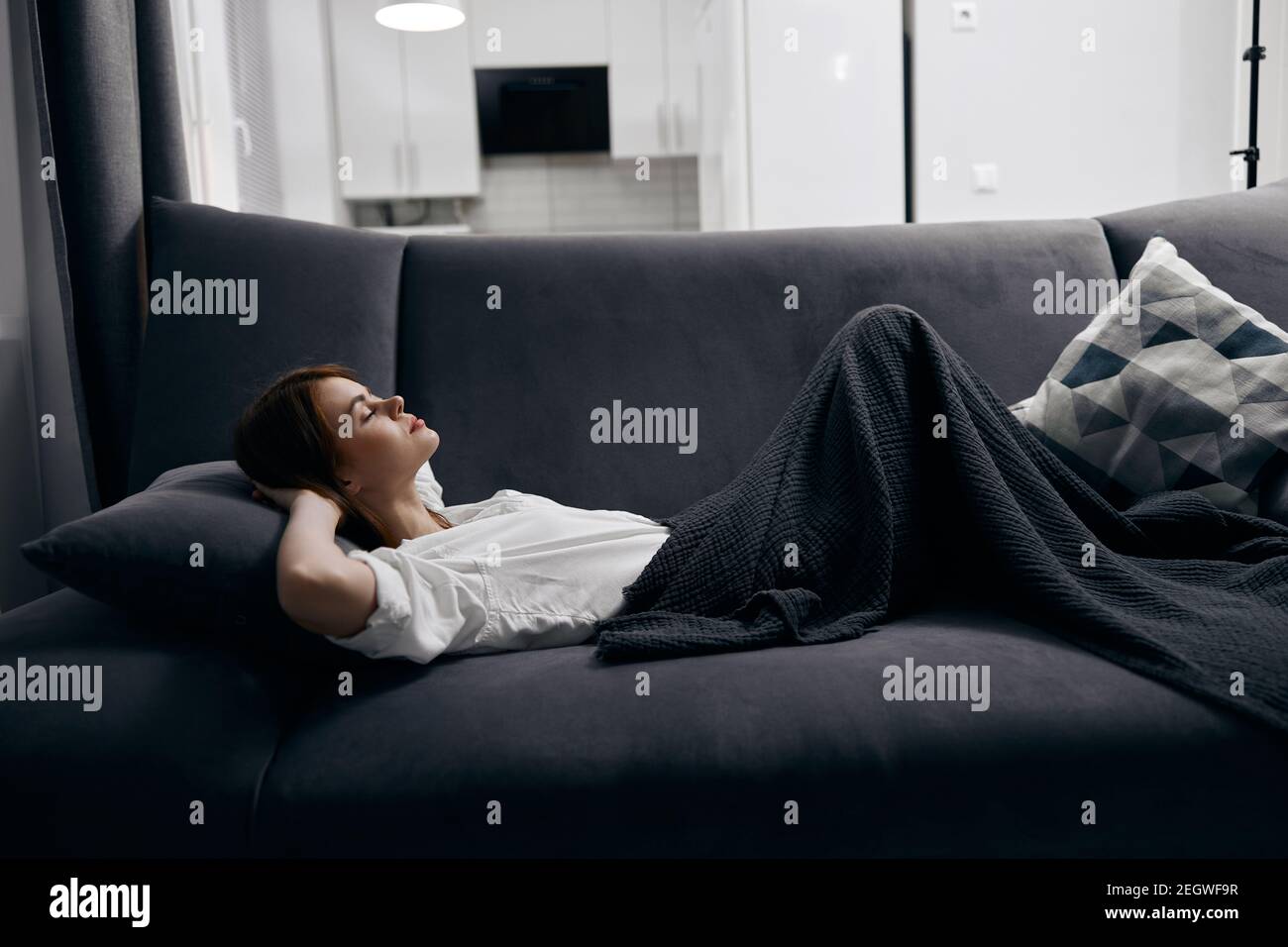 Tired woman lies on sofa hi-res stock photography and images - Alamy