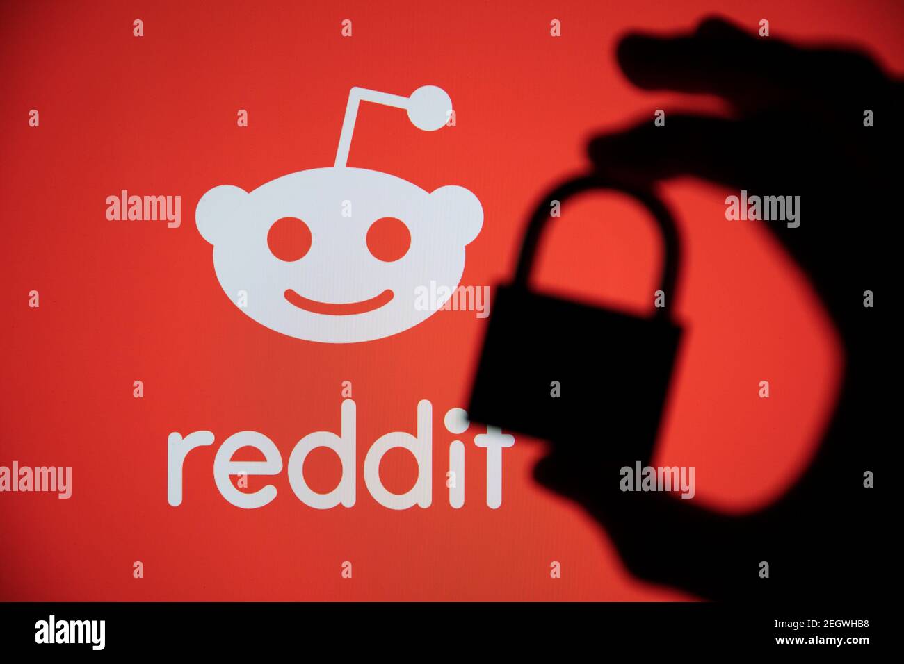 LONDON, UK - February 2021: Silhouette of padlock against Reddit logo ...