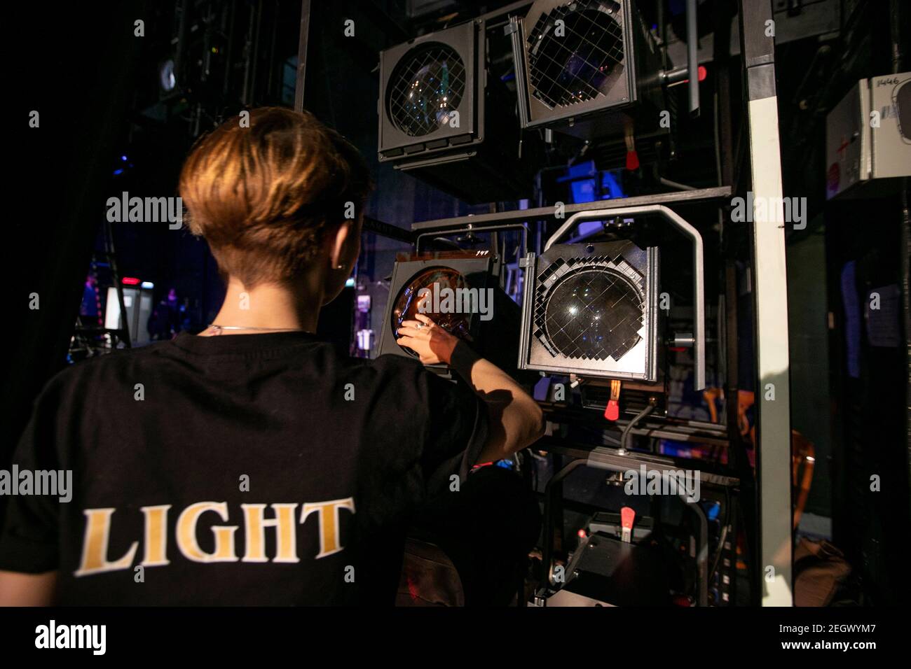 A lighting worker prepares the lamps before the performance begins ...