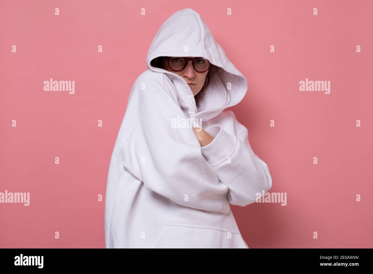 Young woman scared, afraid and anxious, hiding face, looking at camera ...
