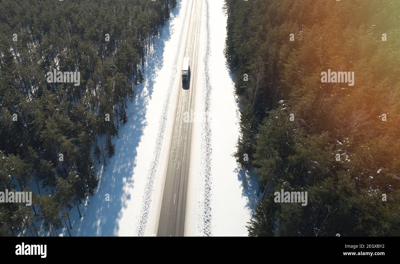 One lorry truck carry cargo on winter road aerial above top drone view ...