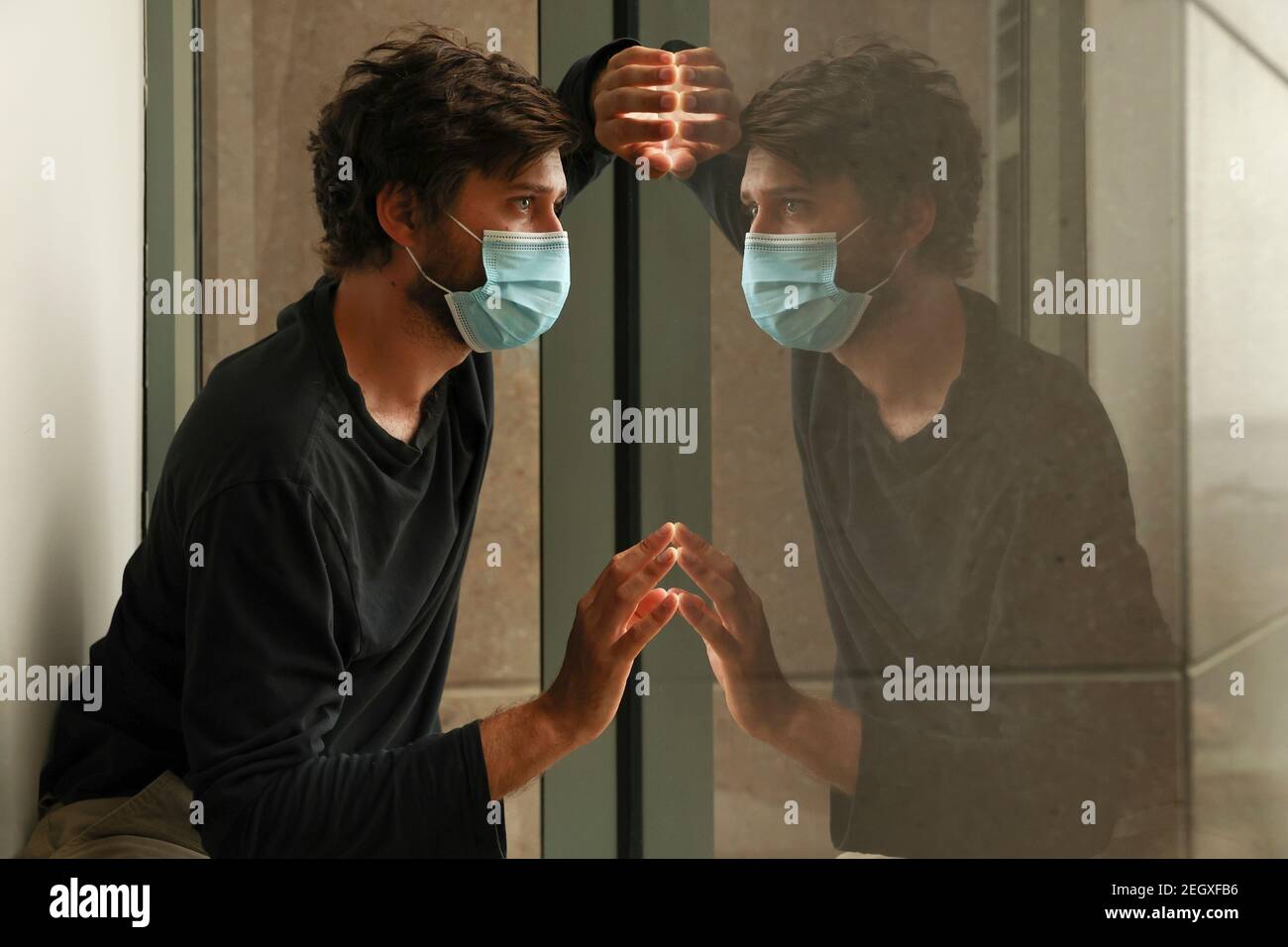 Sad man in isolation due to coronavirus world pandemic. Male in hotel ...