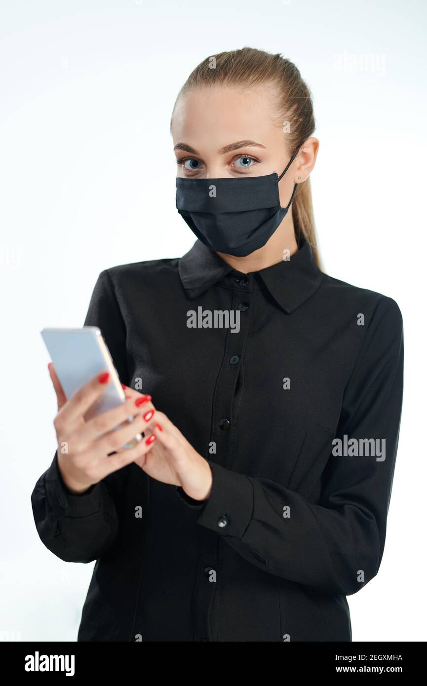 Woman in mask wearing mask isolated on studio background Stock Photo ...