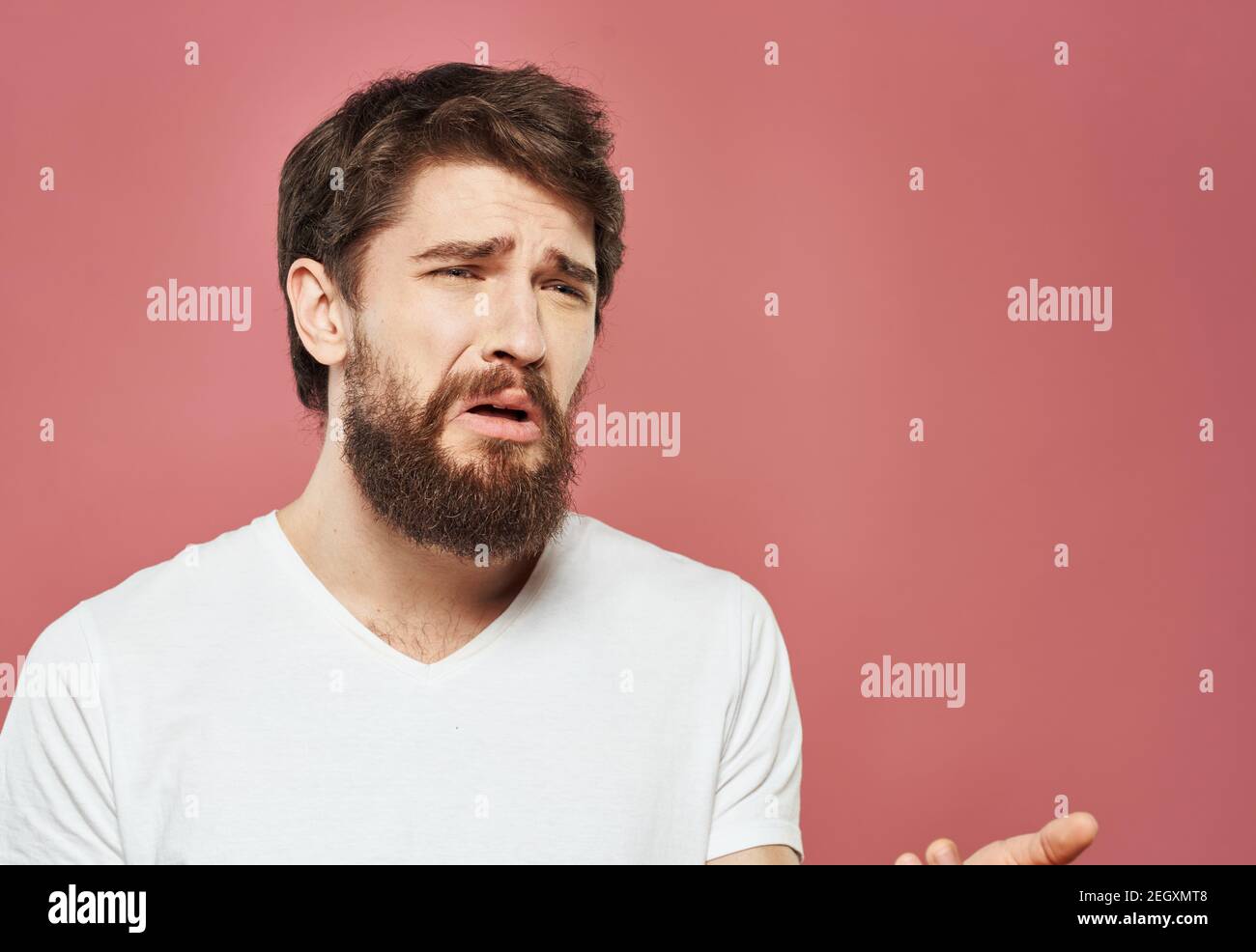 Man on pink background emotions model cropped view puzzled look sad ...