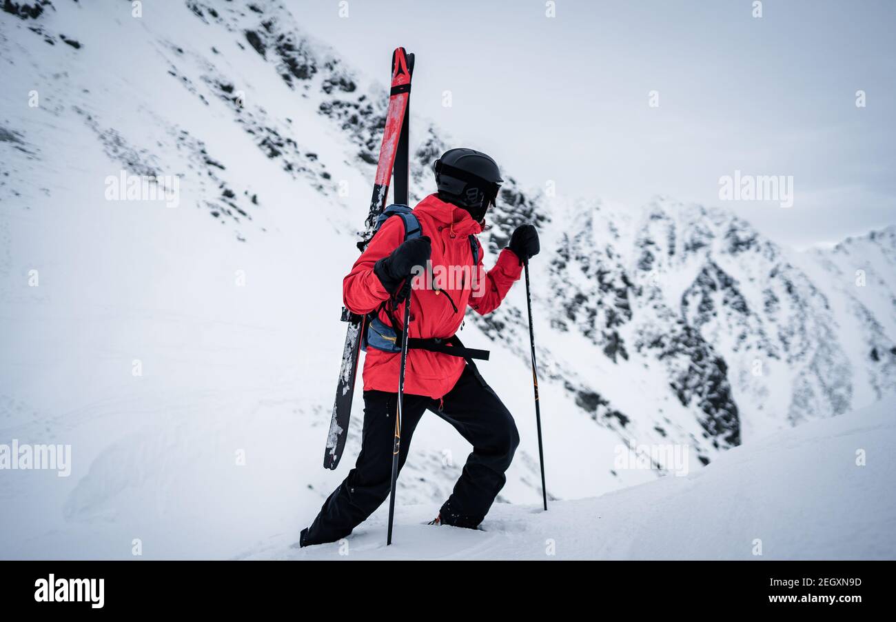 Skier is standing on top of the mountain and looking at the beautiful ...