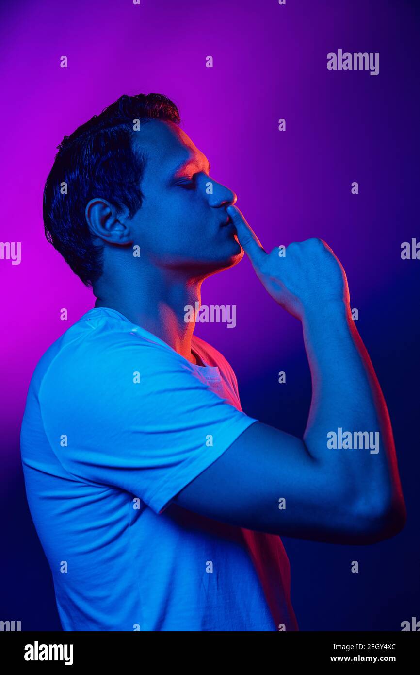 Caucasian man's portrait on purple blue studio background in ...