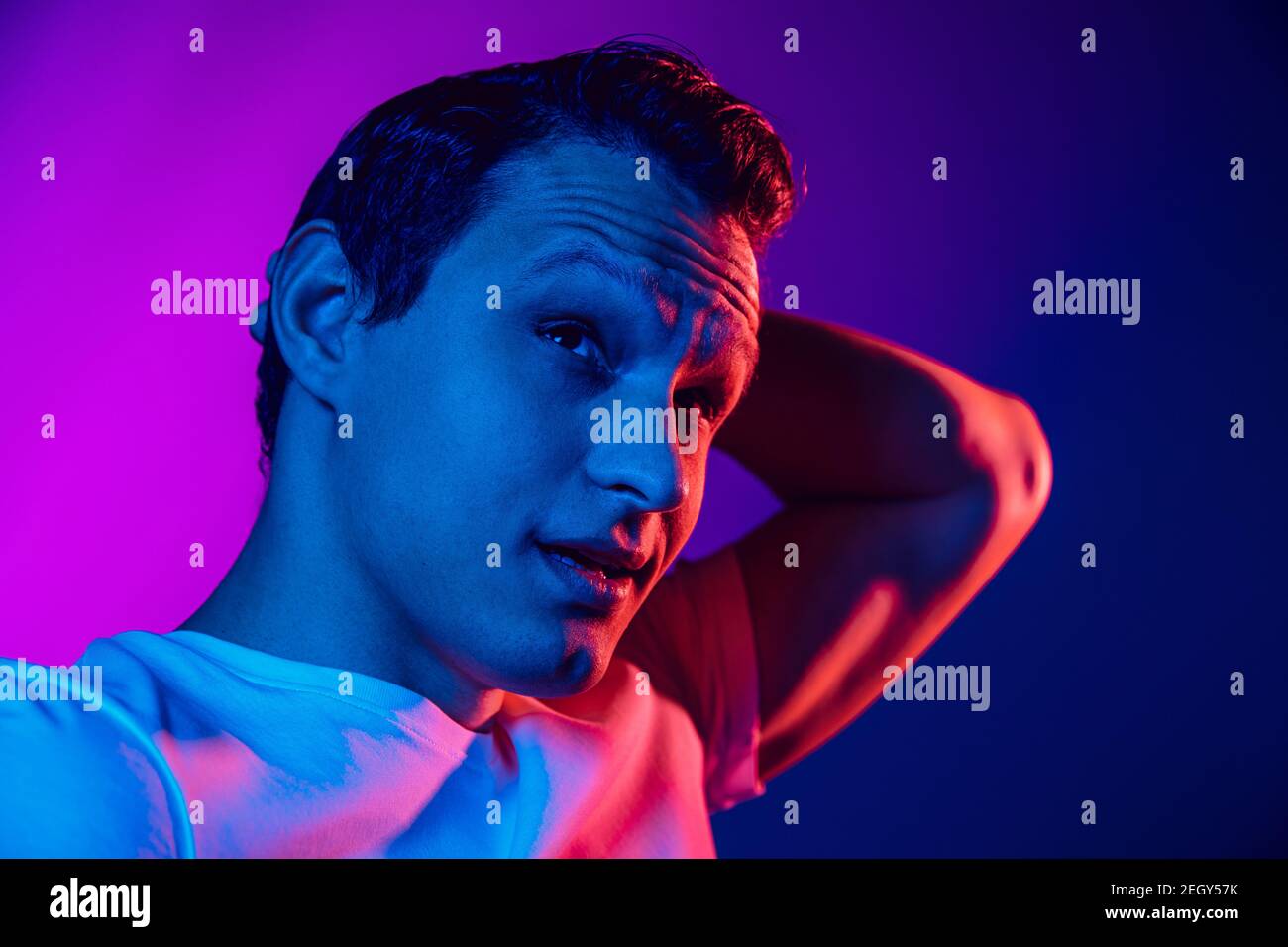 Caucasian man's portrait on purple blue studio background in ...
