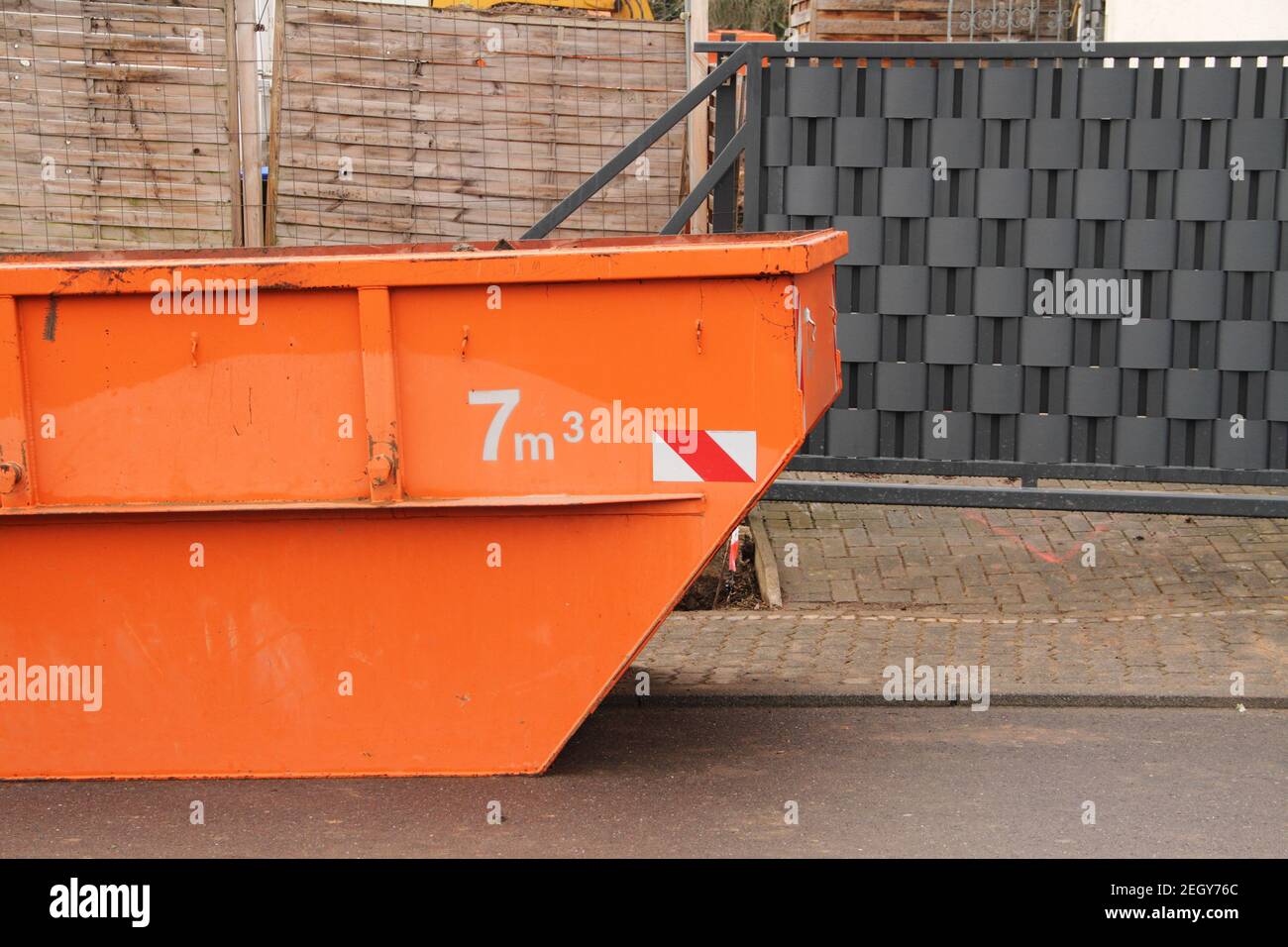 an old orange construction waste container on the street Stock Photo ...