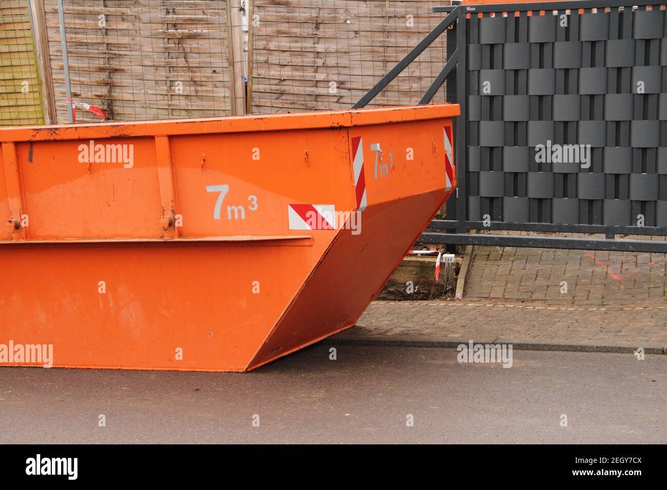 an old orange construction waste container on the street Stock Photo ...