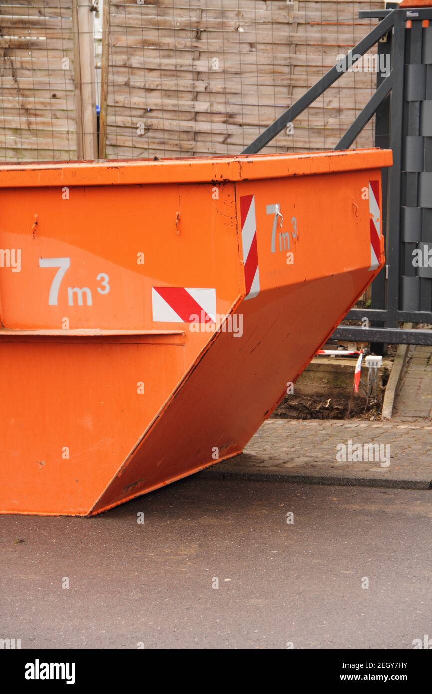 an old orange construction waste container on the street Stock Photo ...