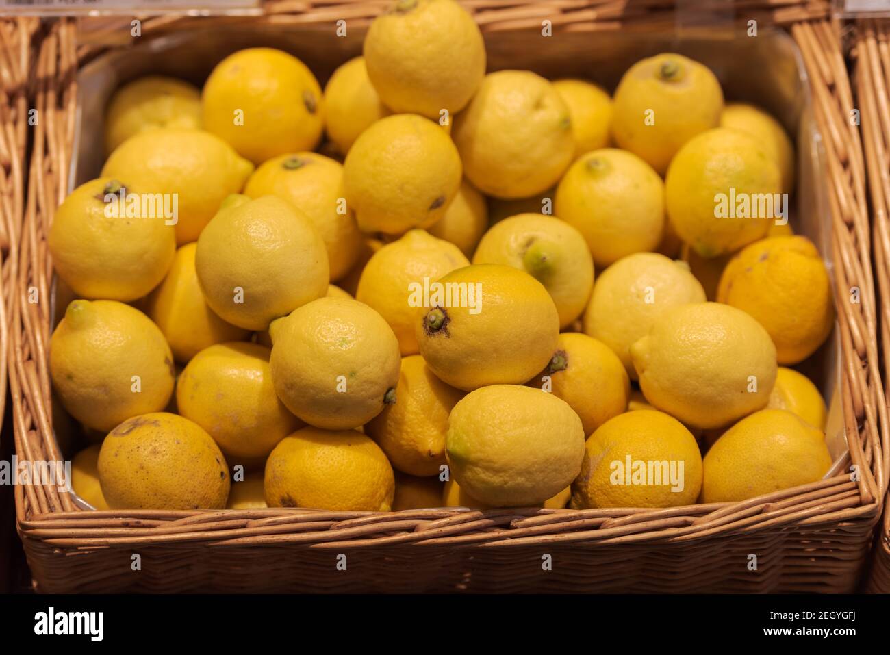 Unpacked organic lemons in basket on display in organic super market ...