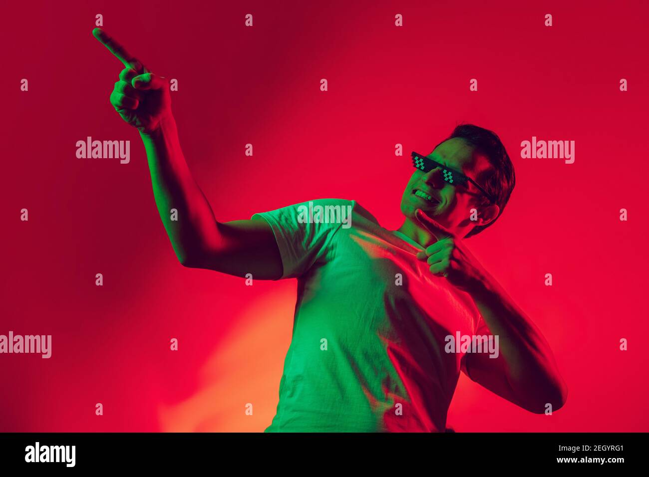 Stylish. Caucasian man's portrait isolated on red studio background in ...