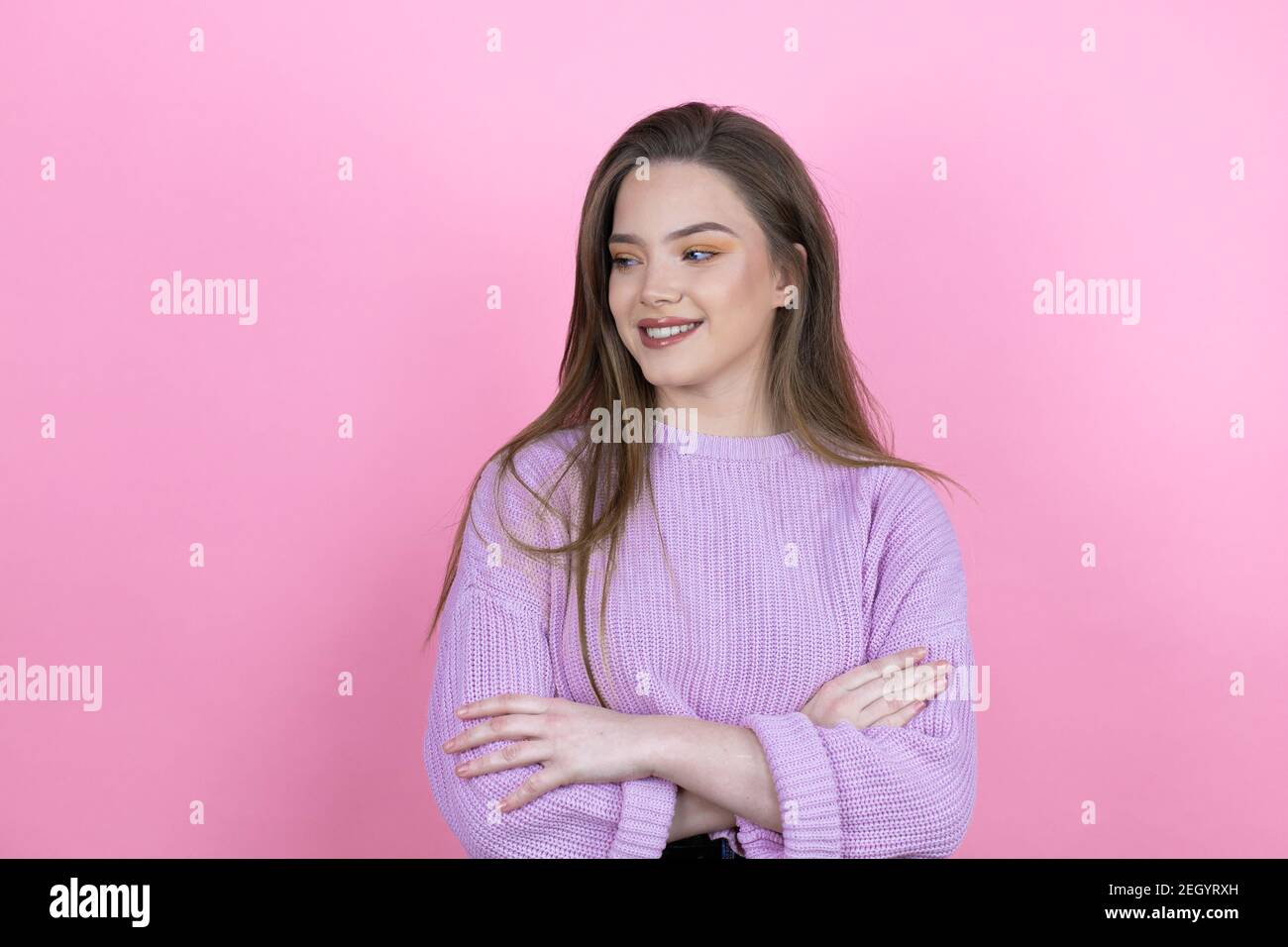 Young pretty woman with long hair standing over isolated pink ...