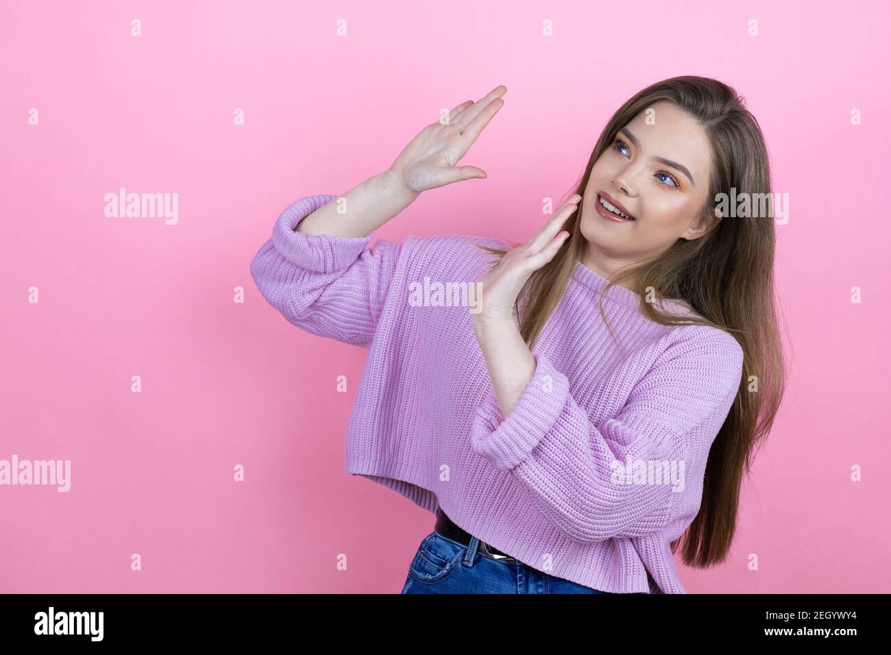 Young pretty woman with long hair standing over isolated pink ...