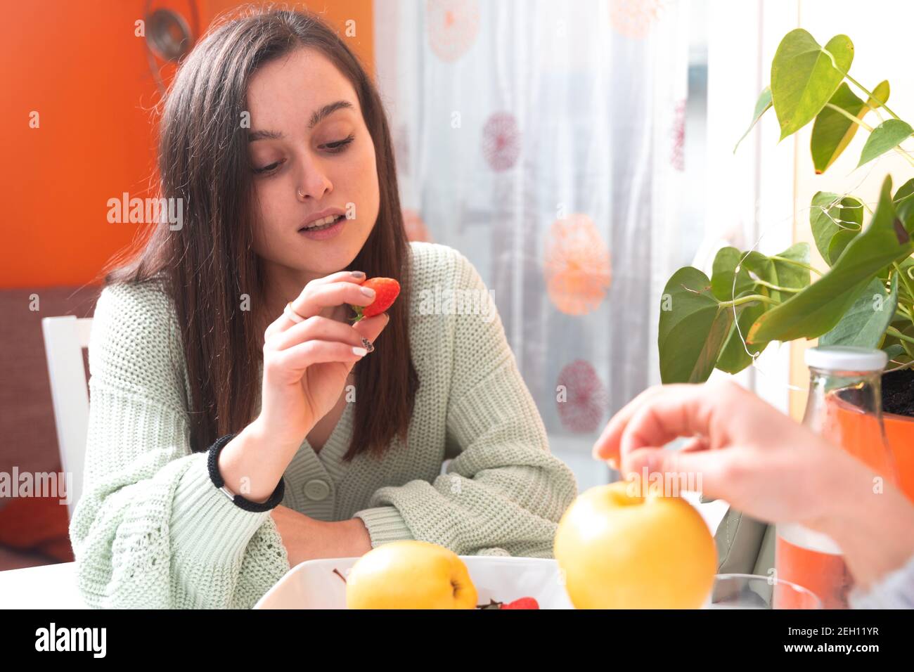 Women eating fruits at the living room Stock Photo - Alamy