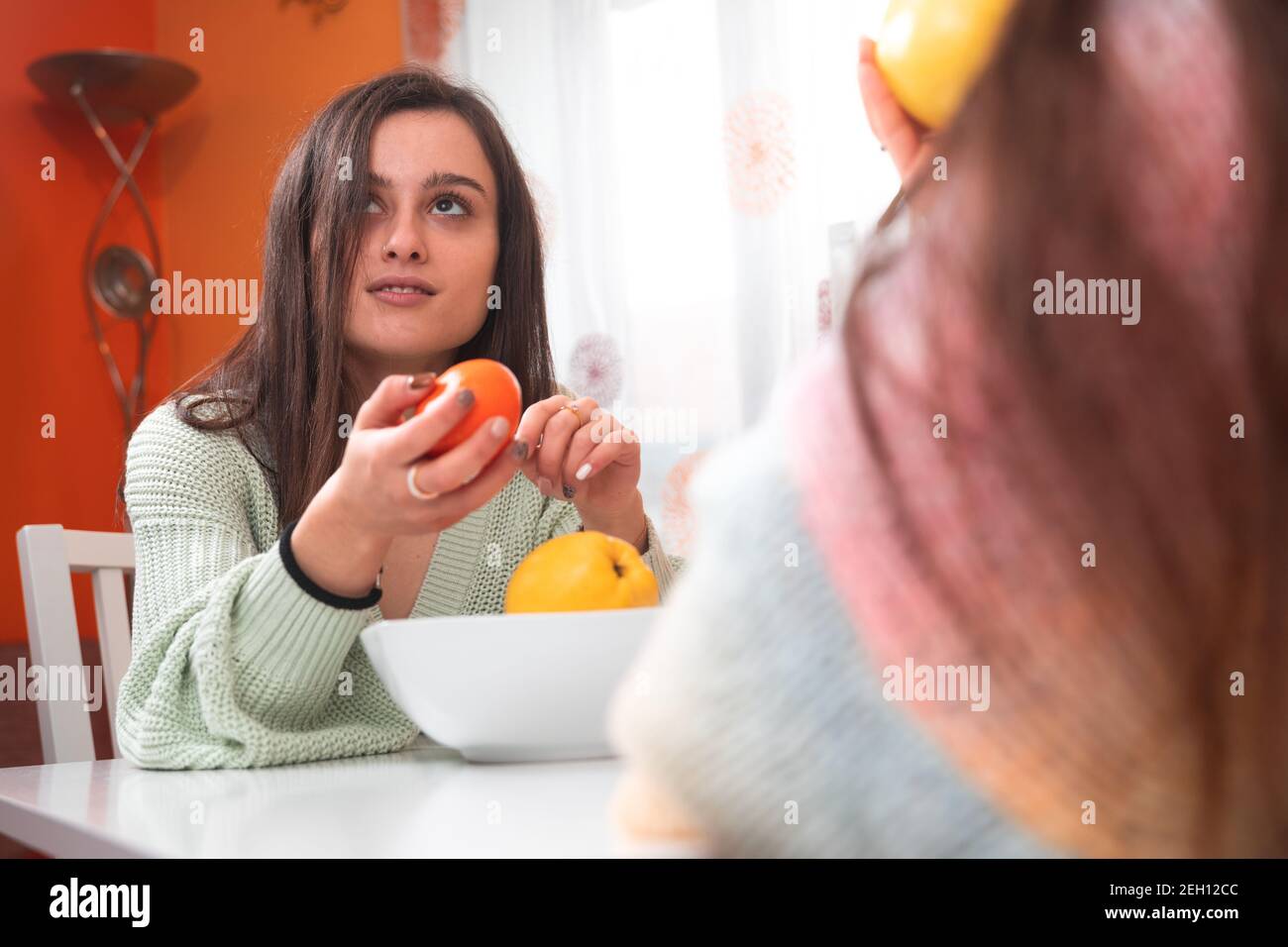 Women eating fruits at the living room Stock Photo - Alamy