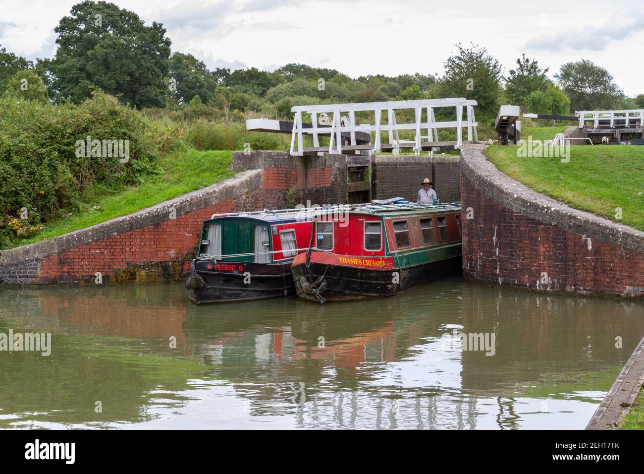 A pair of canal boats coming through the bottom lock at the Caen Hill ...
