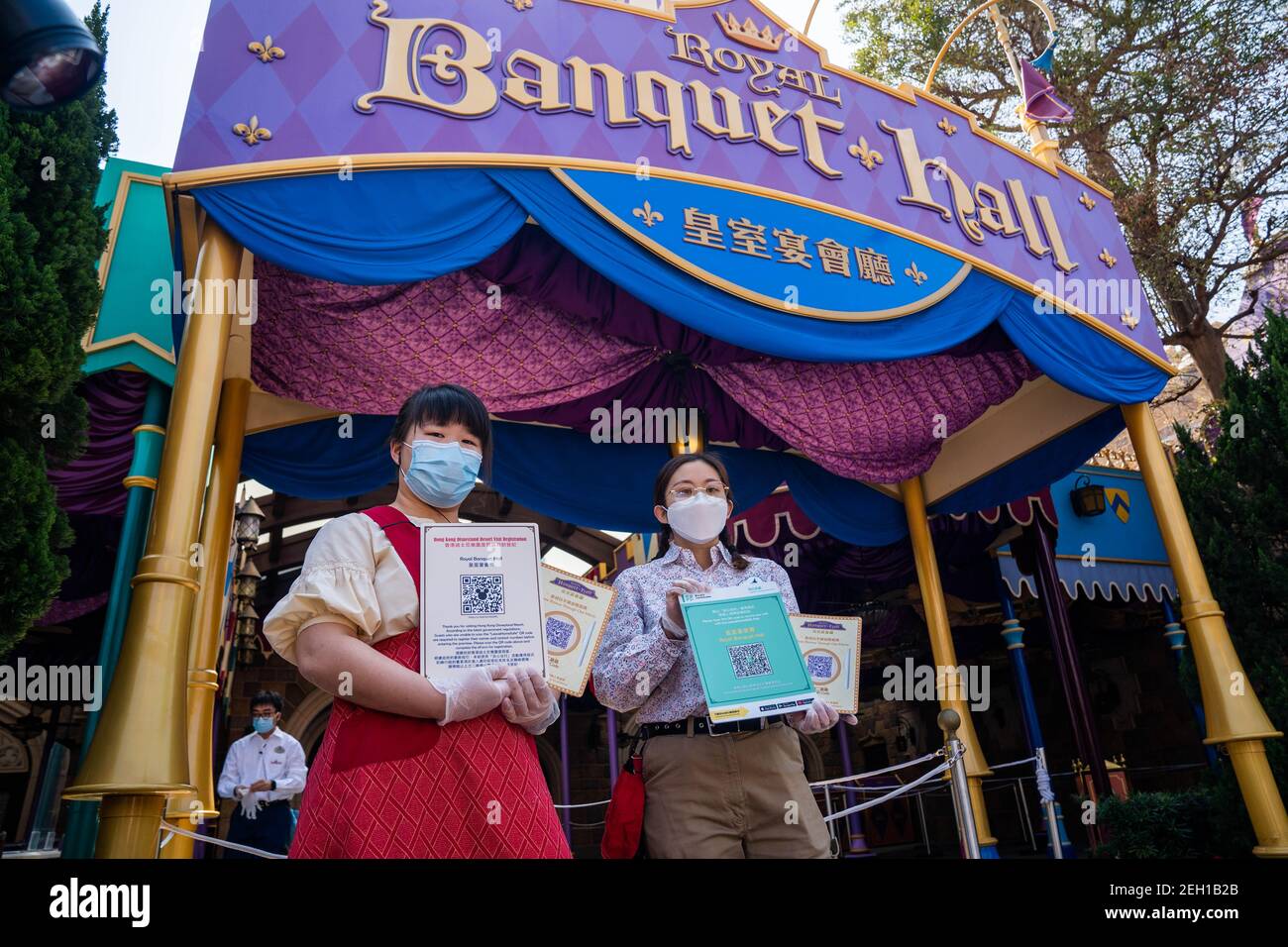 Employees of the Hong Kong Disneyland resort seen holding the health QR ...
