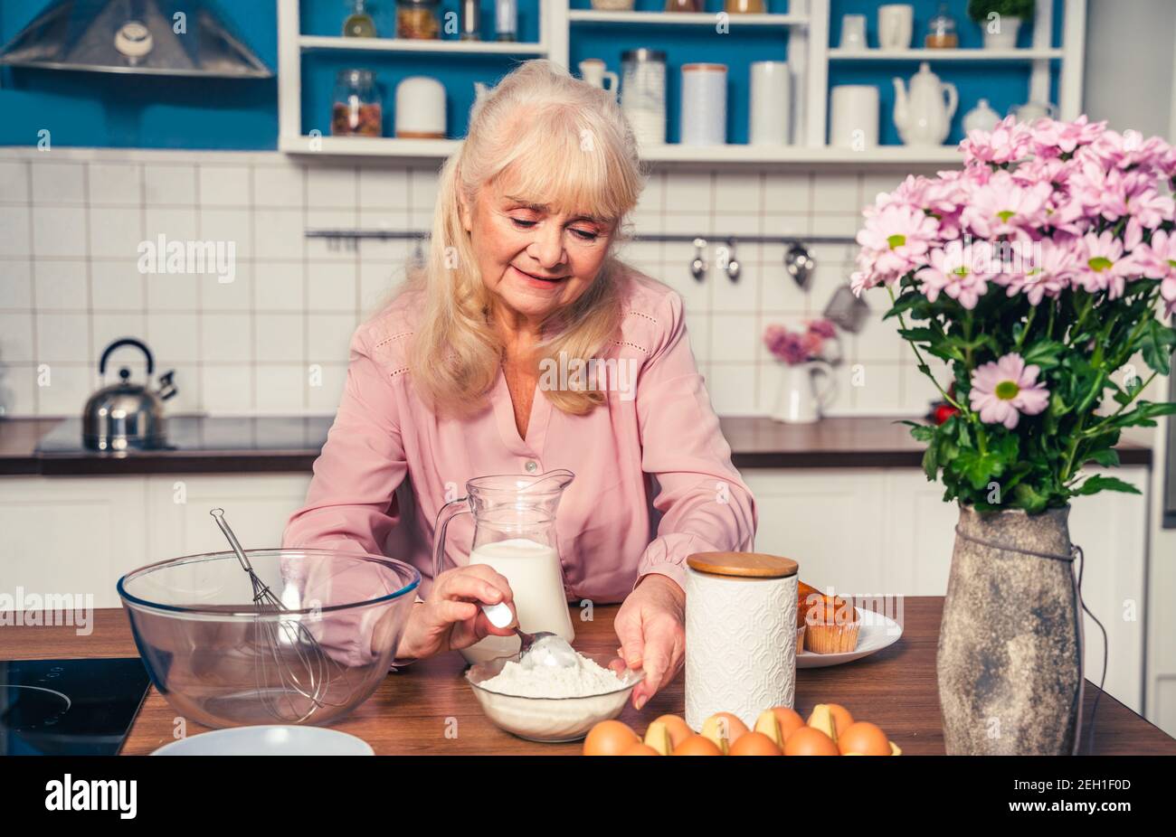 Beautiful senior woman baking in the kitchen - Grandmother preparing ...