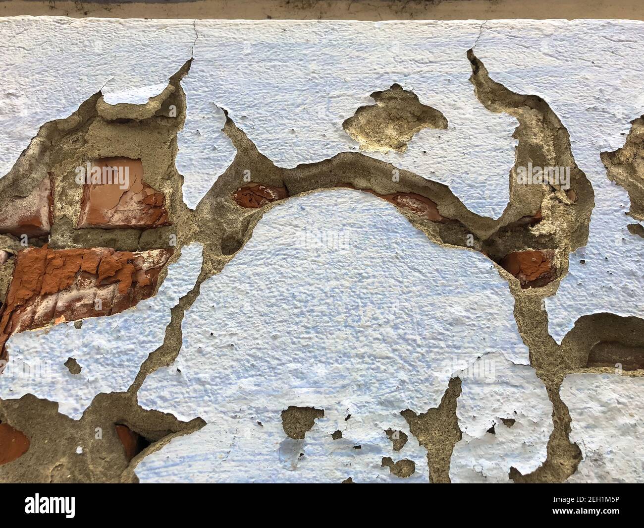 The surface of an old dilapidated wall with deep cracks. Red bricks ...