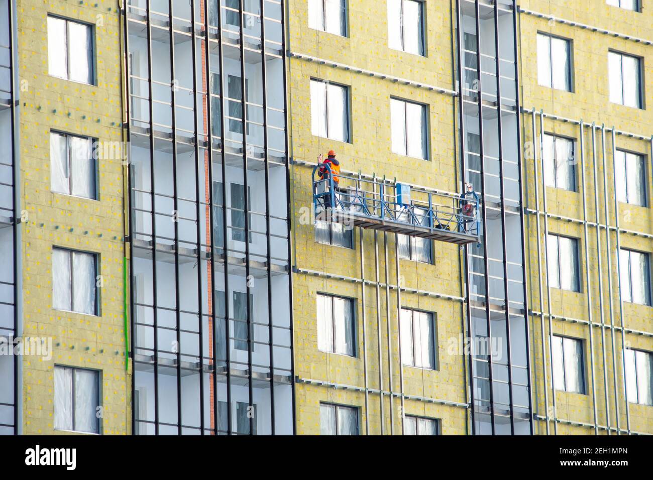 Finishing the facade of residential buildings by workers on the ...