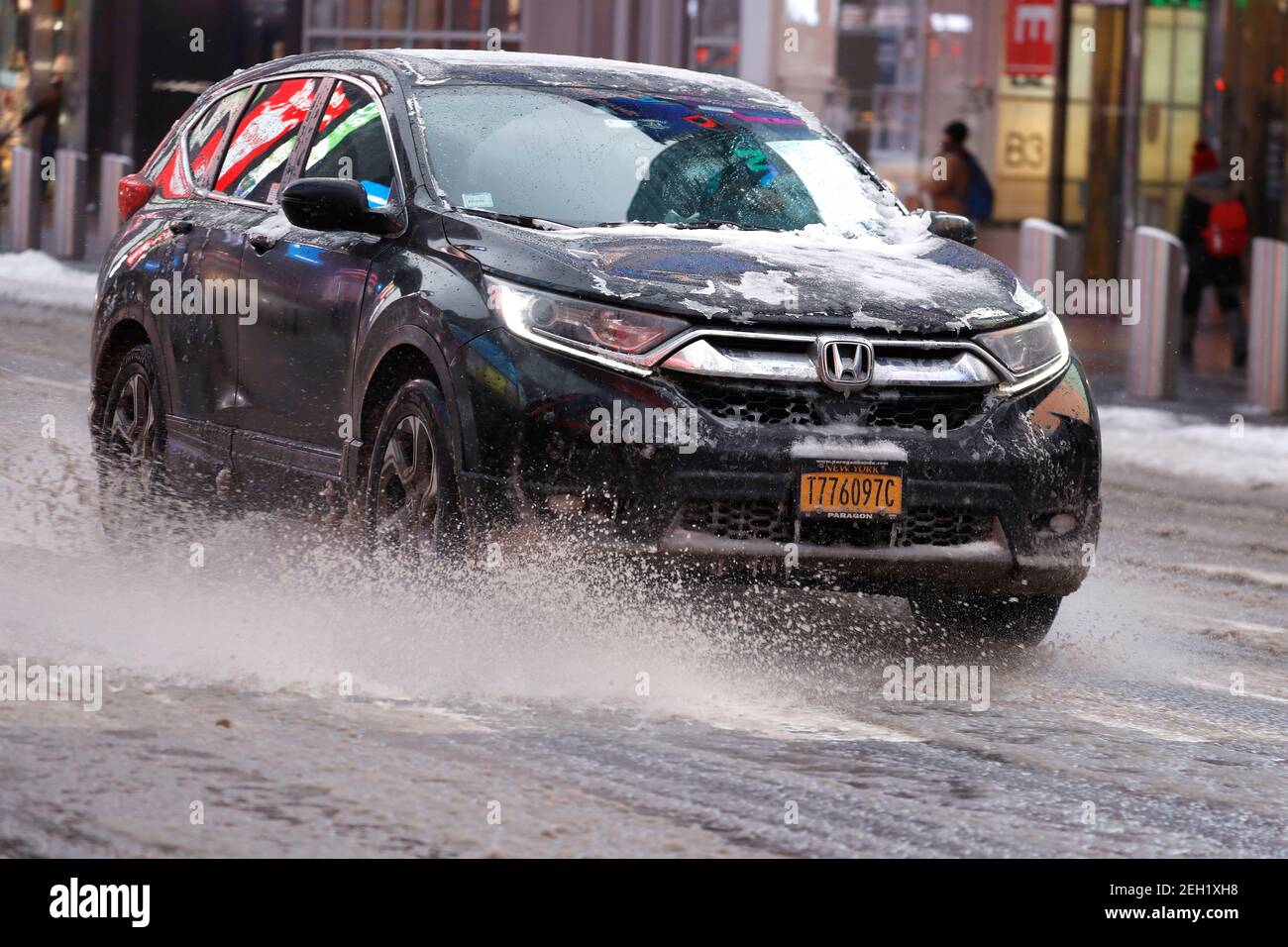 Car drives at a speed through slush during a snow storm in Times Square ...