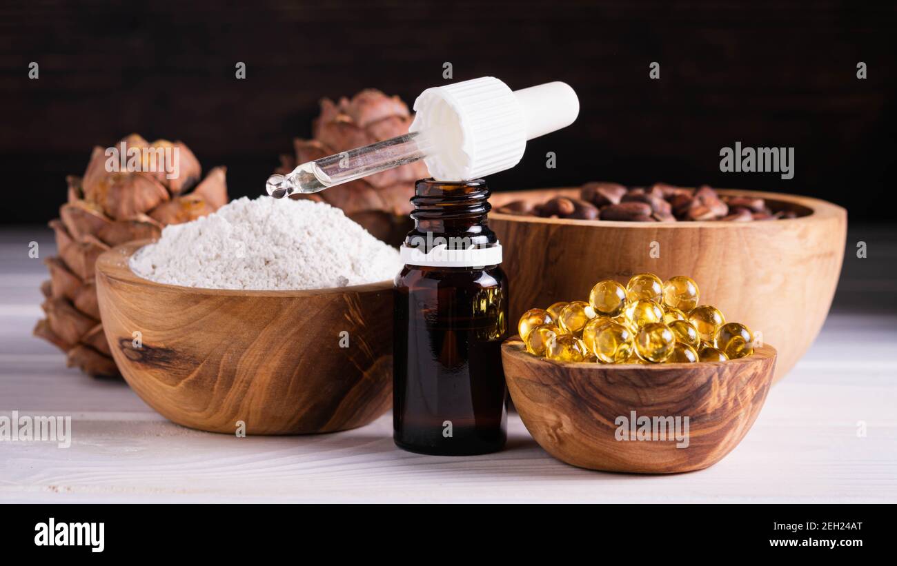 Natural product concept,Pine nuts, oil, extract on white wood teble ...