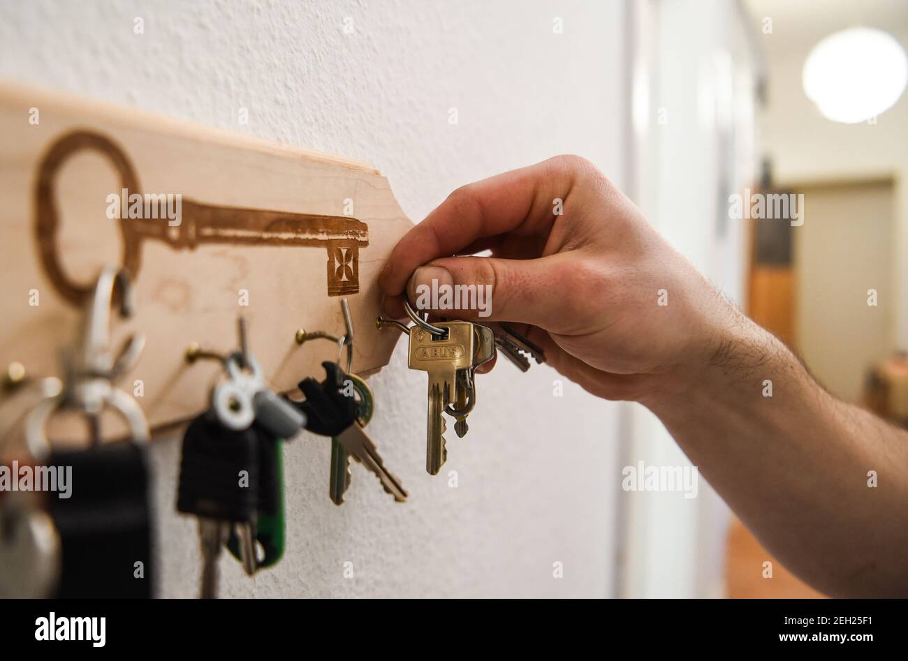 Berlin, Germany. 18th Feb, 2021. A man hangs a bunch of keys on a hook ...