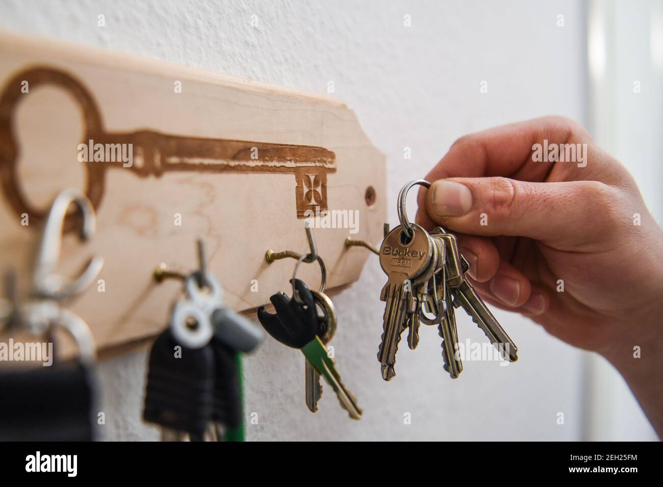 Berlin, Germany. 18th Feb, 2021. A man hangs a bunch of keys on a hook ...