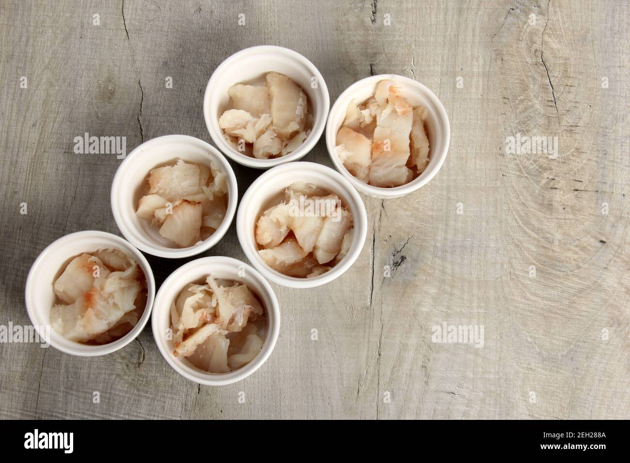 several dishes with raw fresh fish pieces before frying. dishes with ...