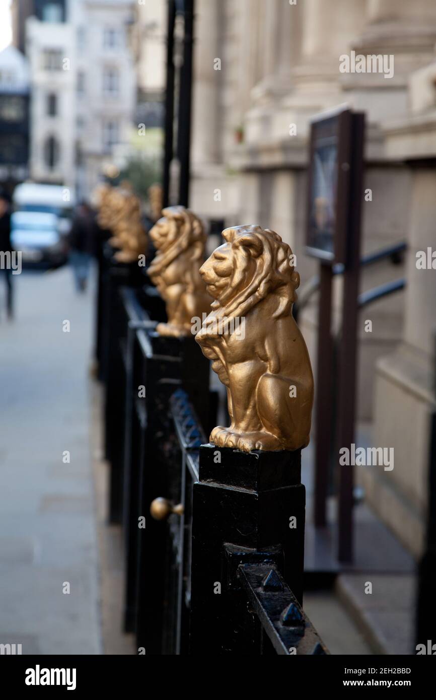 golden lion figures on a black ironing railing Stock Photo - Alamy