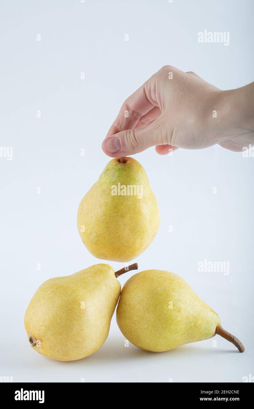 Woman hands holding pear on white background Stock Photo - Alamy