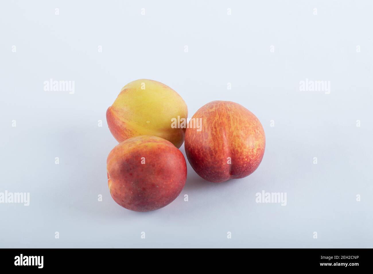 Three fresh nectarines on a white background Stock Photo - Alamy