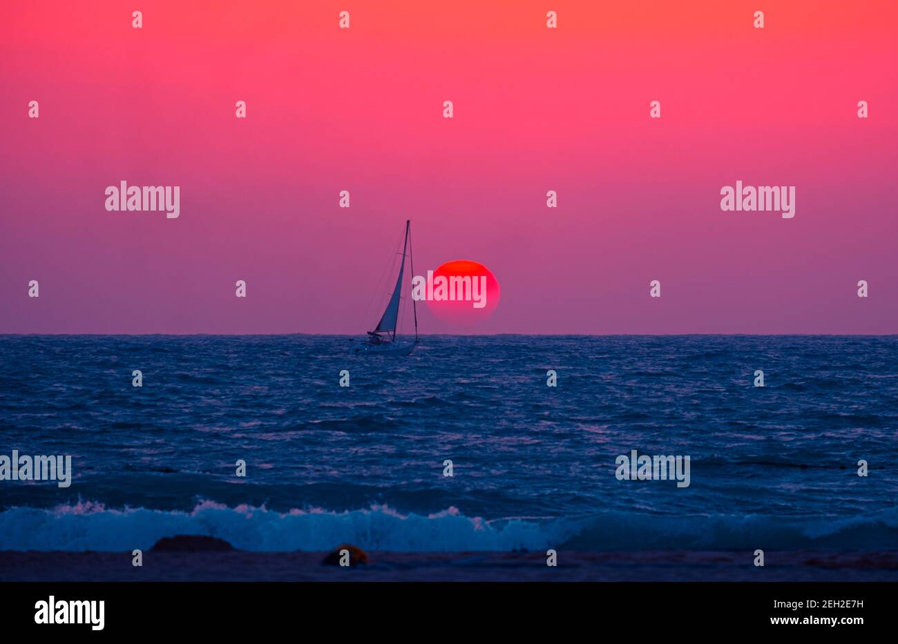 Mesmerizing view of the sailing sailboat on the wavy ocean against the ...