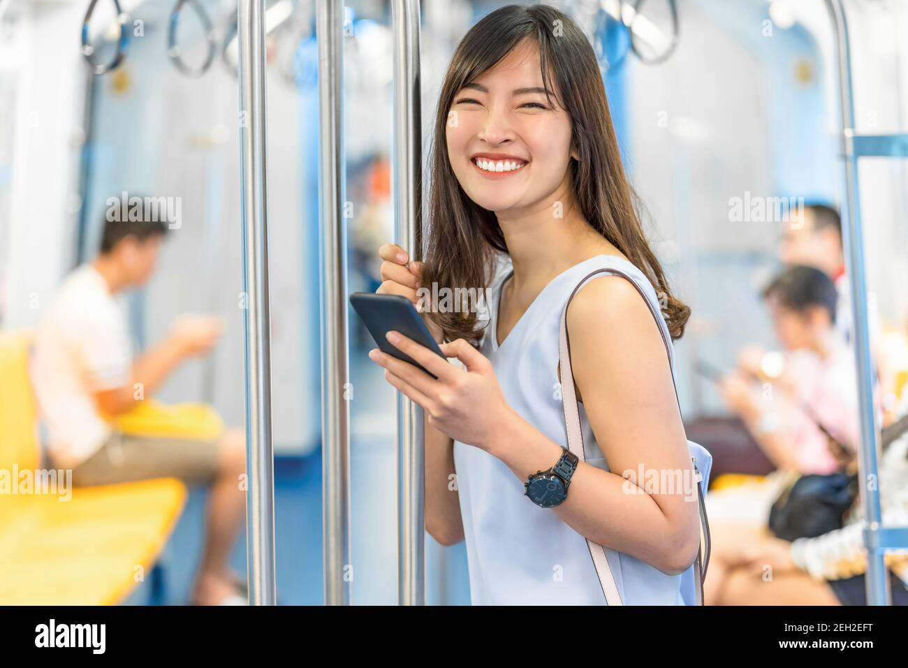Young Asian woman passenger using social network via smart mobile phone ...