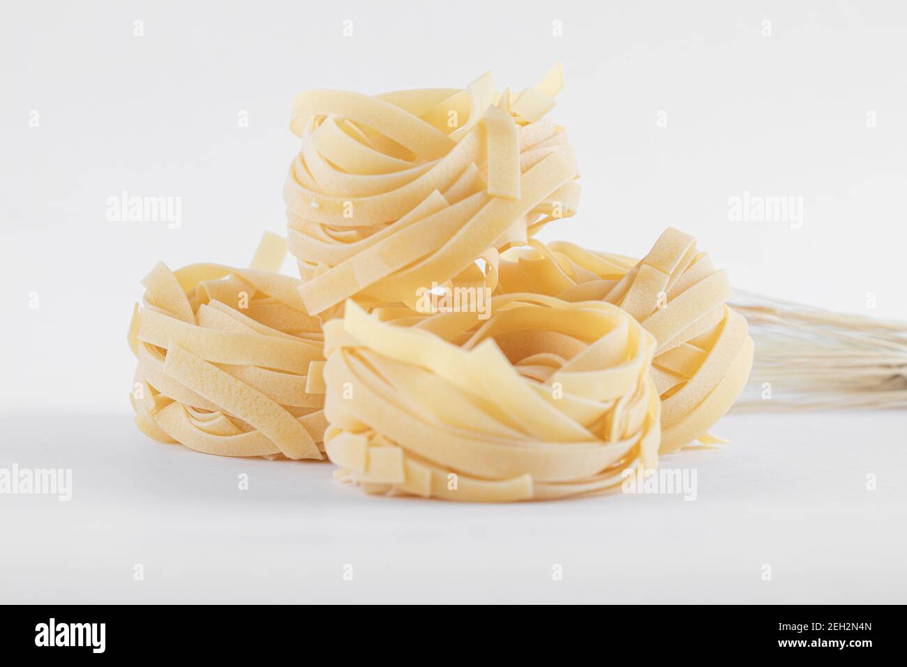 Dry tagliatelle nests on white background view Stock Photo - Alamy