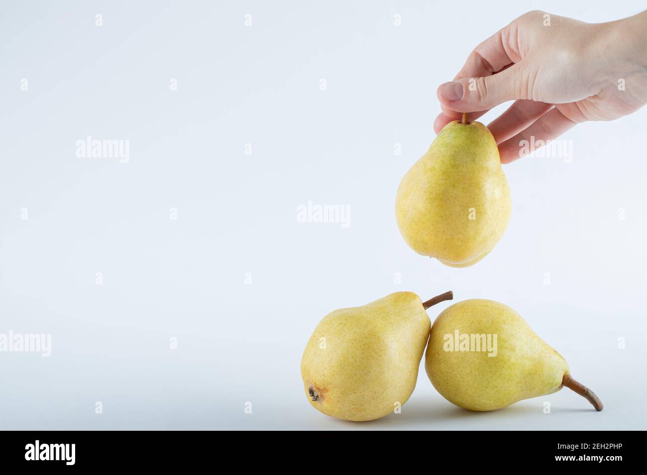 Female hands holding pear on white background Stock Photo - Alamy