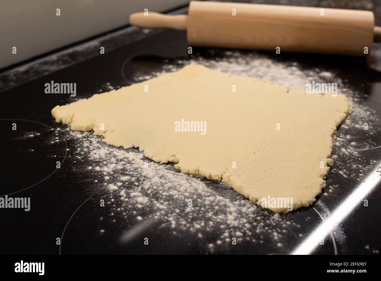 Raw dough flattened with wooden rolling pin Stock Photo - Alamy