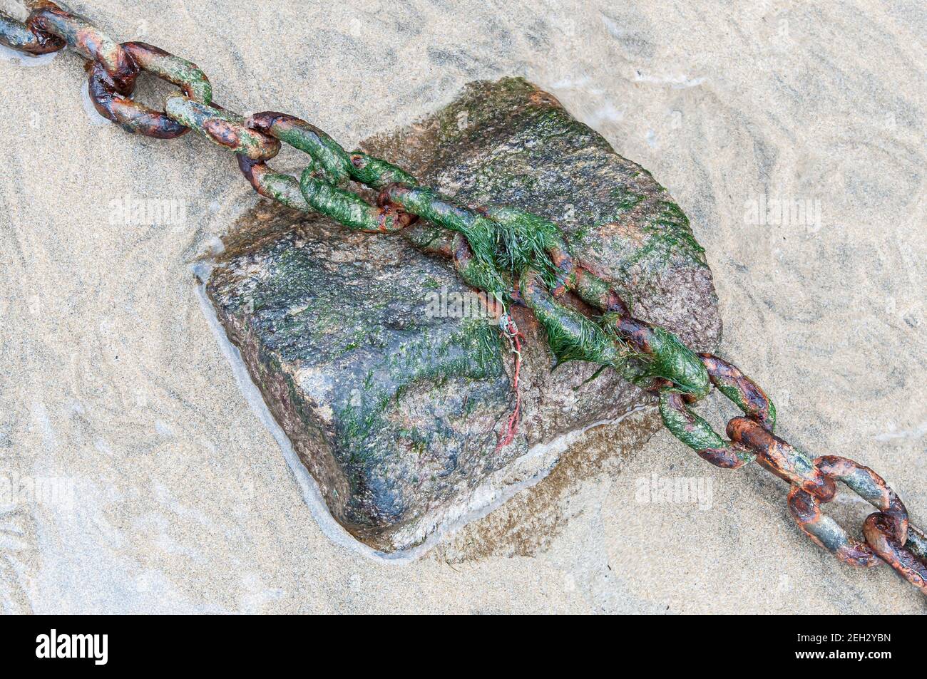 Chain and block on sandy beach Stock Photo - Alamy