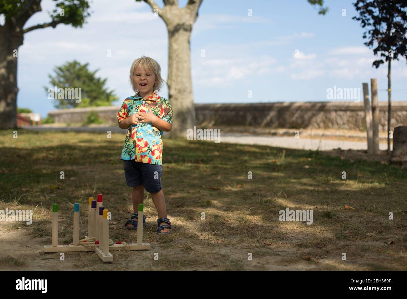 Child, boy, playing game with hoops and rings, throwing and trying to ...