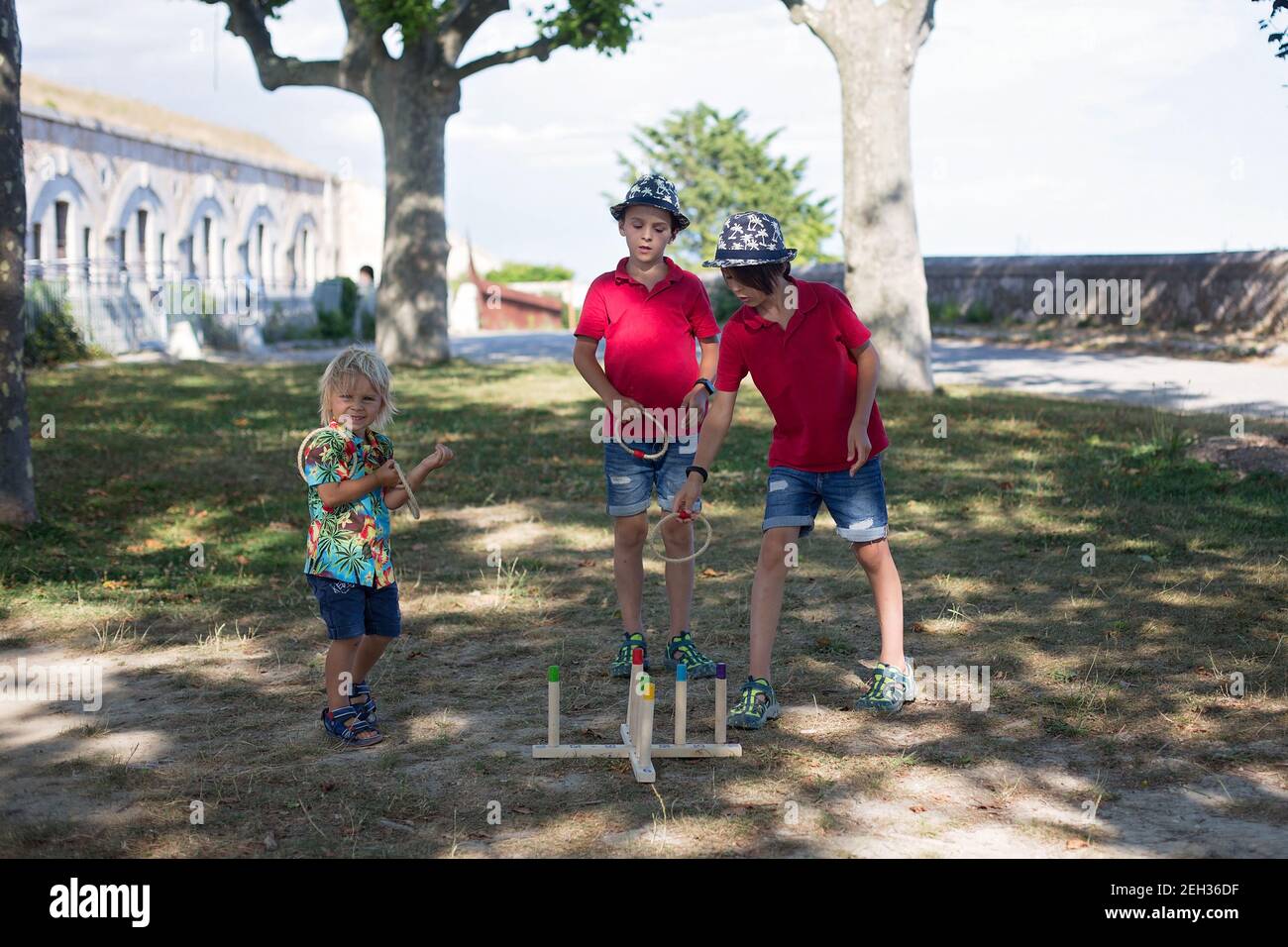 Children, boys, playing game with hoops and rings, throwing and trying ...