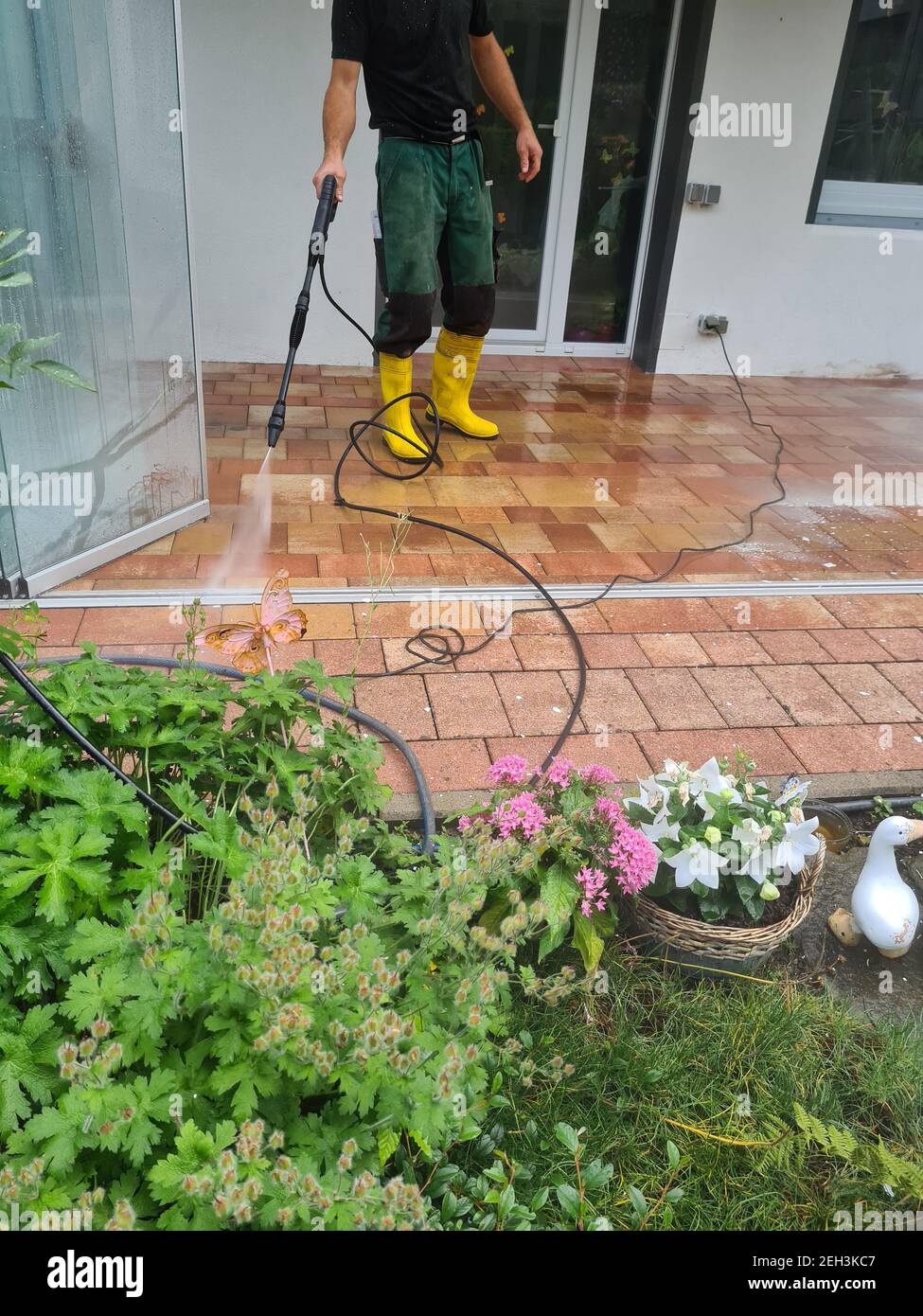 Man power washing conservatory roof and windows Stock Photo - Alamy