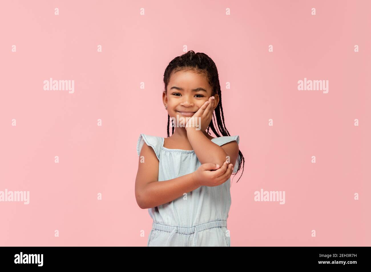 Shy. Happy longhair brunette little girl isolated on pink studio ...