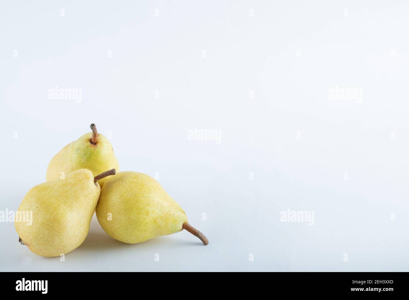 Three yellow pears on white background, soft focus Stock Photo - Alamy