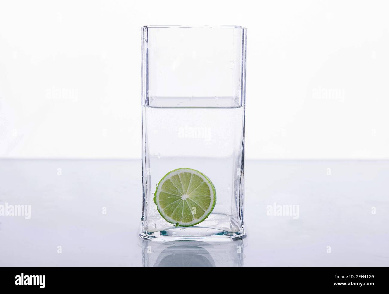 Lime splashing into glass of water on white background and Stock Photo ...