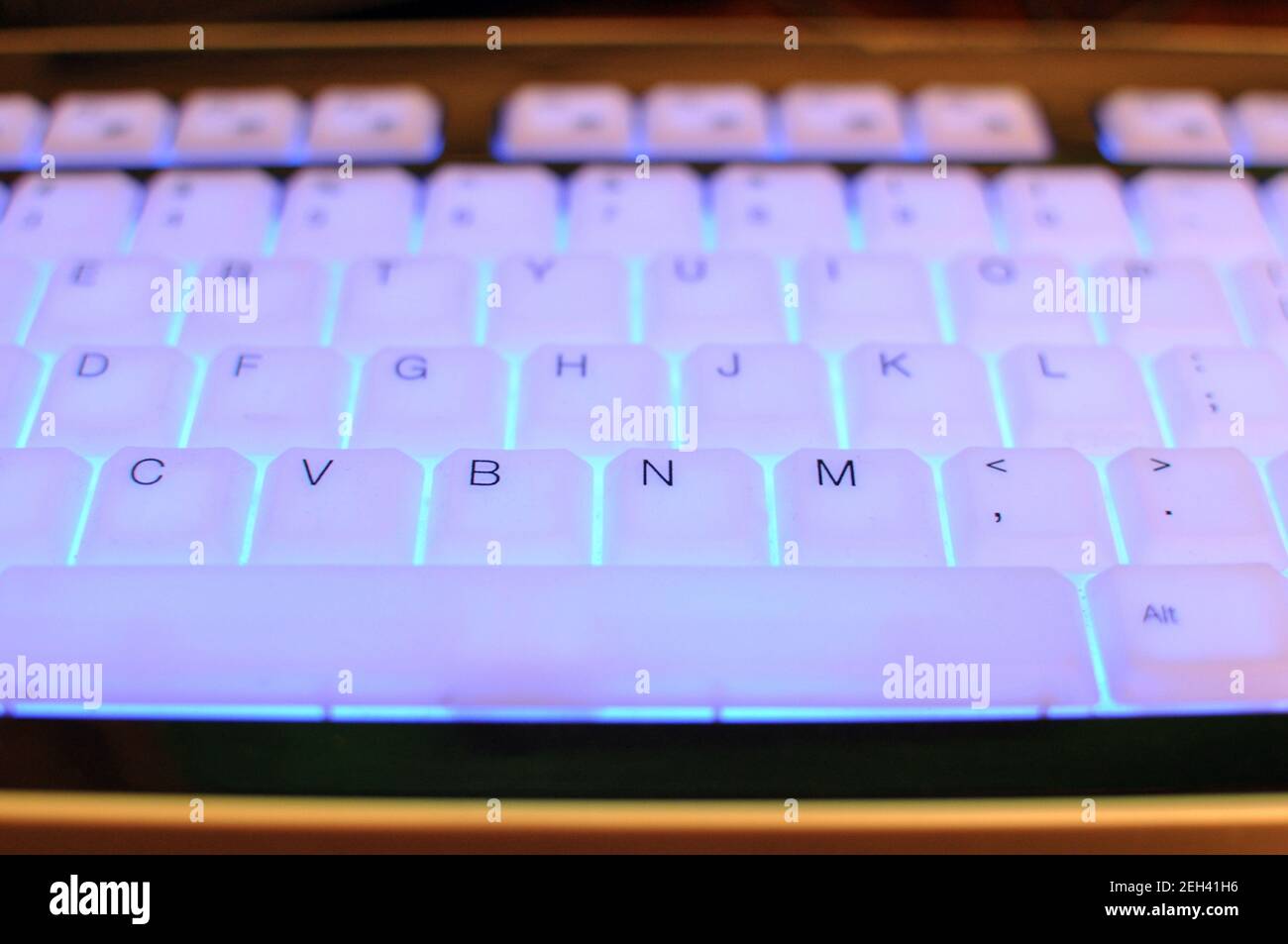 Top side view of an illuminated keyboard with black letters on white ...